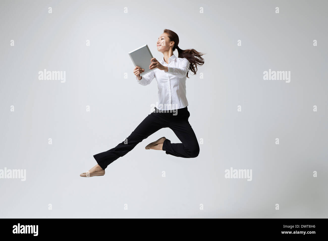 a woman making dance poses with a tablet Stock Photo - Alamy