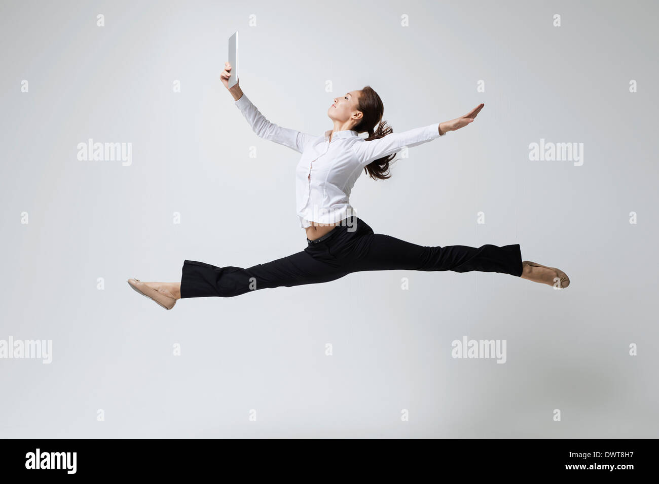 a woman making dance poses with a tablet Stock Photo - Alamy