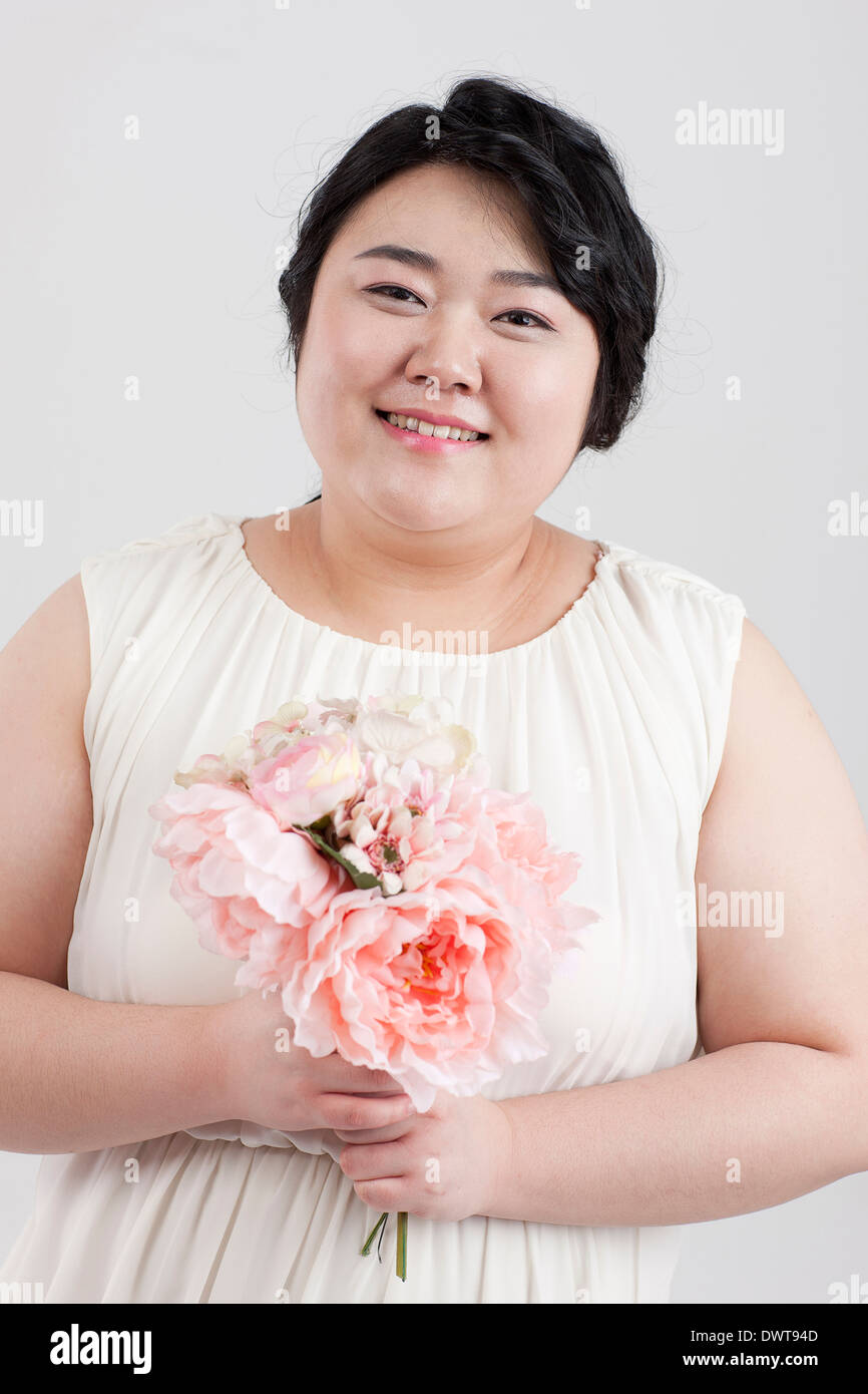 a fat woman posing with flowers Stock Photo - Alamy