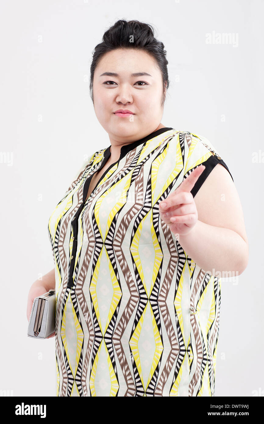 a fat woman in a dress holding a hand bag Stock Photo - Alamy
