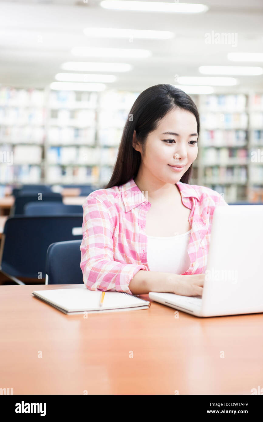a girl sitting in the library studying Stock Photo - Alamy