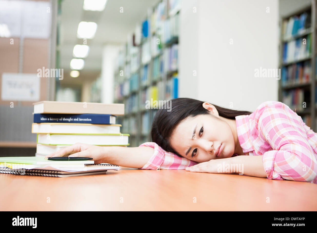 a girl sitting in the library studying Stock Photo - Alamy