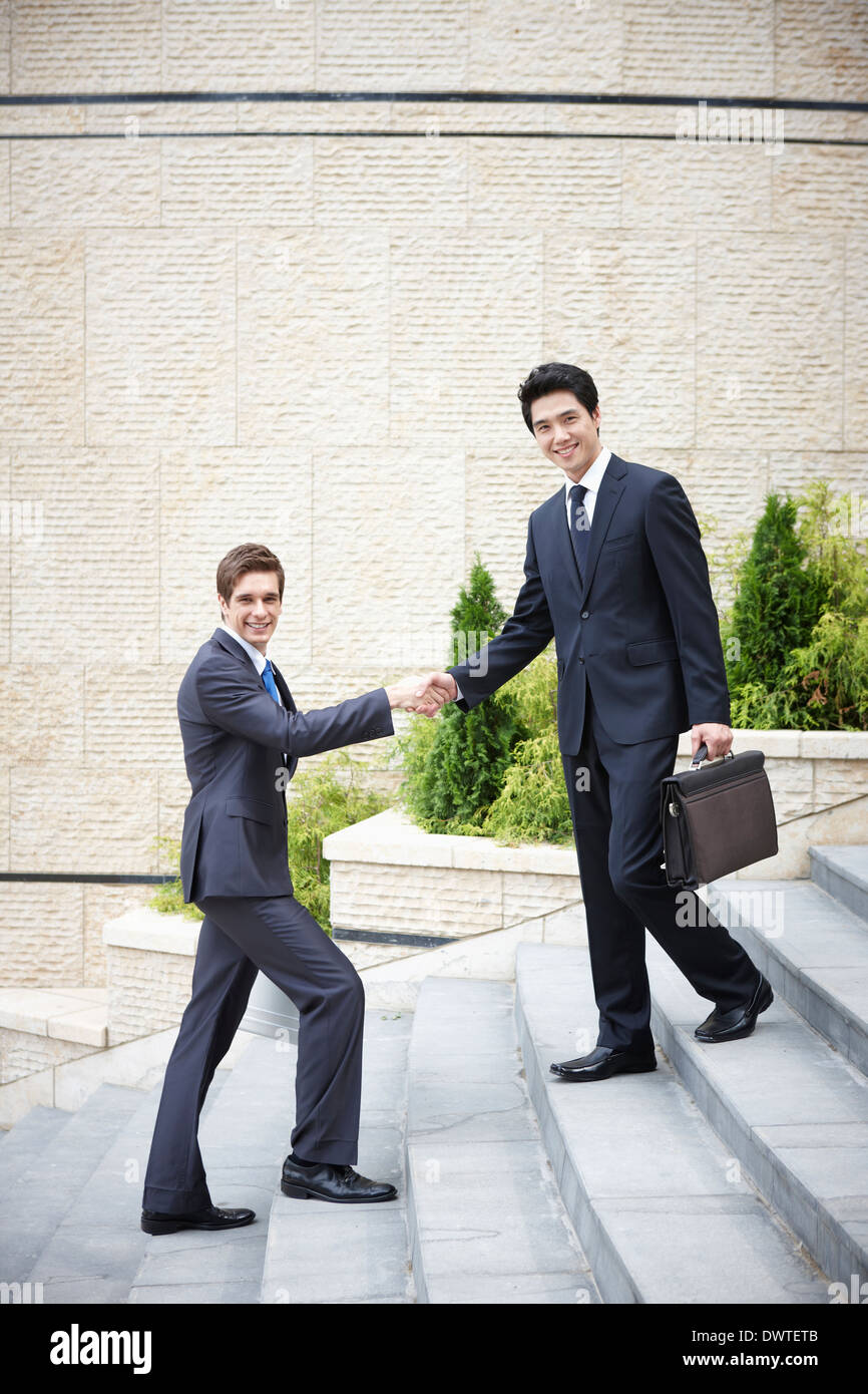two business men shaking hands outside Stock Photo - Alamy