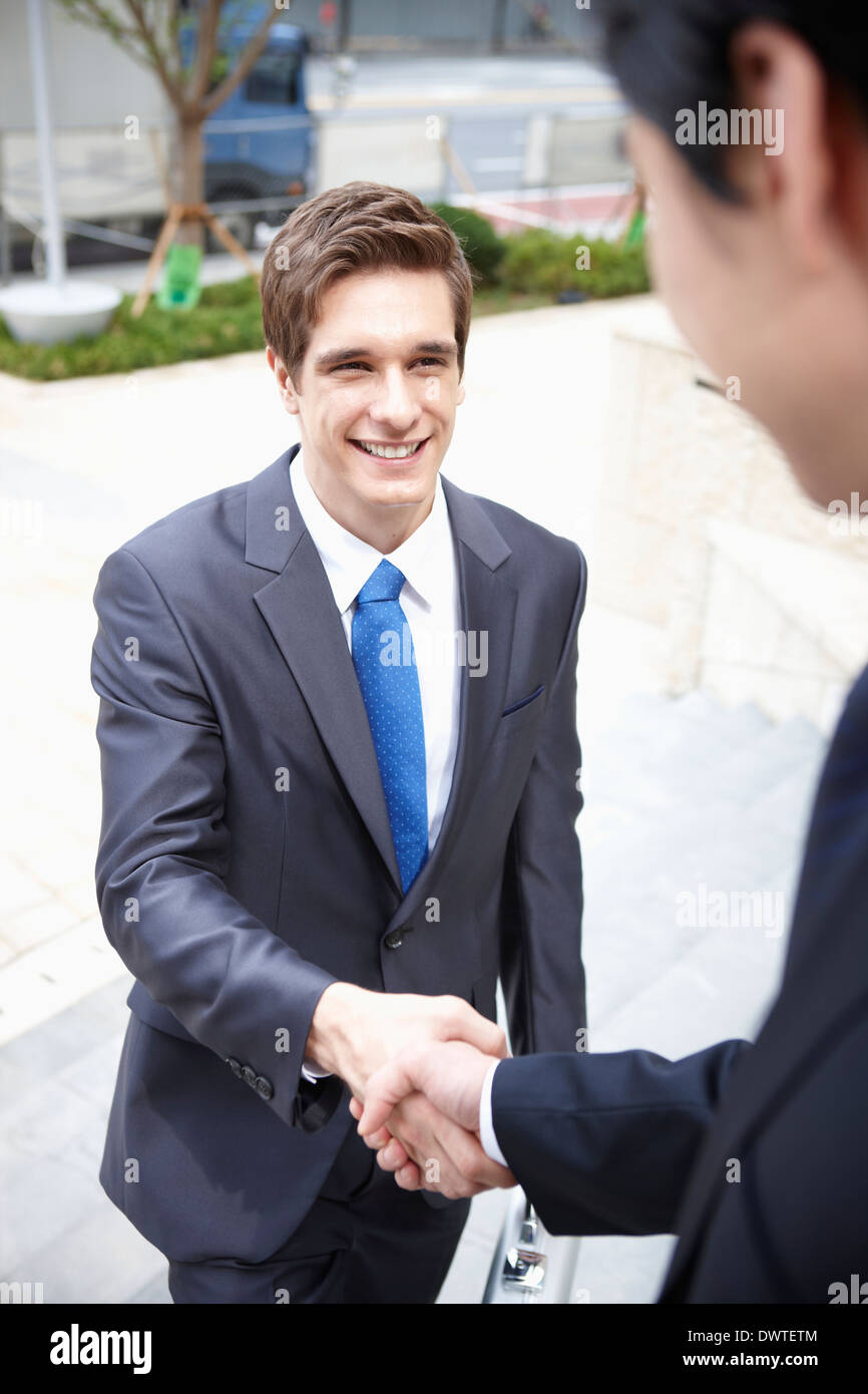two business men shaking hands outside Stock Photo - Alamy
