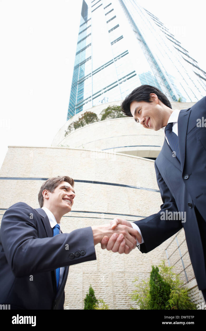 two business men shaking hands outside Stock Photo - Alamy