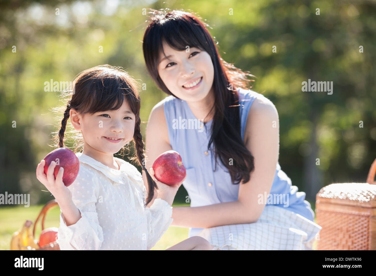 a mother and a daughter eating fruits in the nature Stock Photo - Alamy