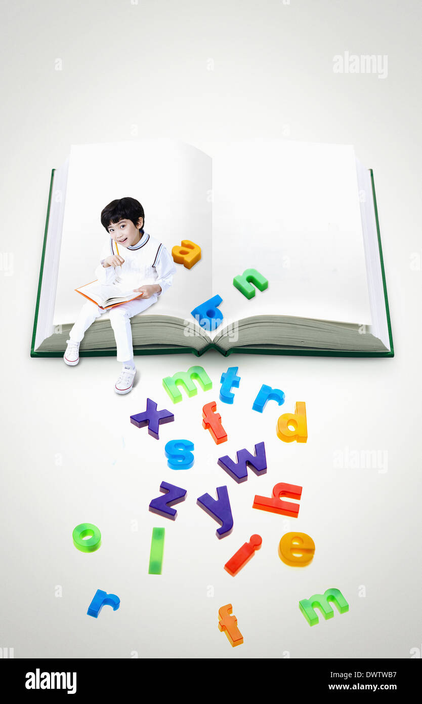 a boy sitting on a book Stock Photo - Alamy