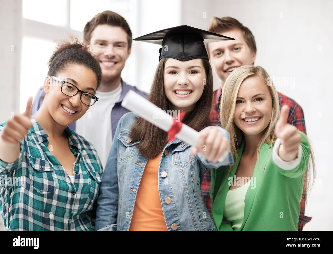 girl in graduation cap with diploma and students Stock Photo - Alamy