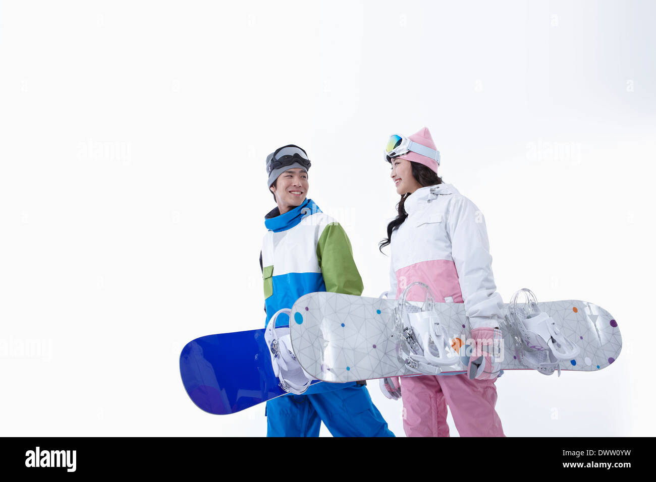 a couple holding snowboards and board gear Stock Photo - Alamy
