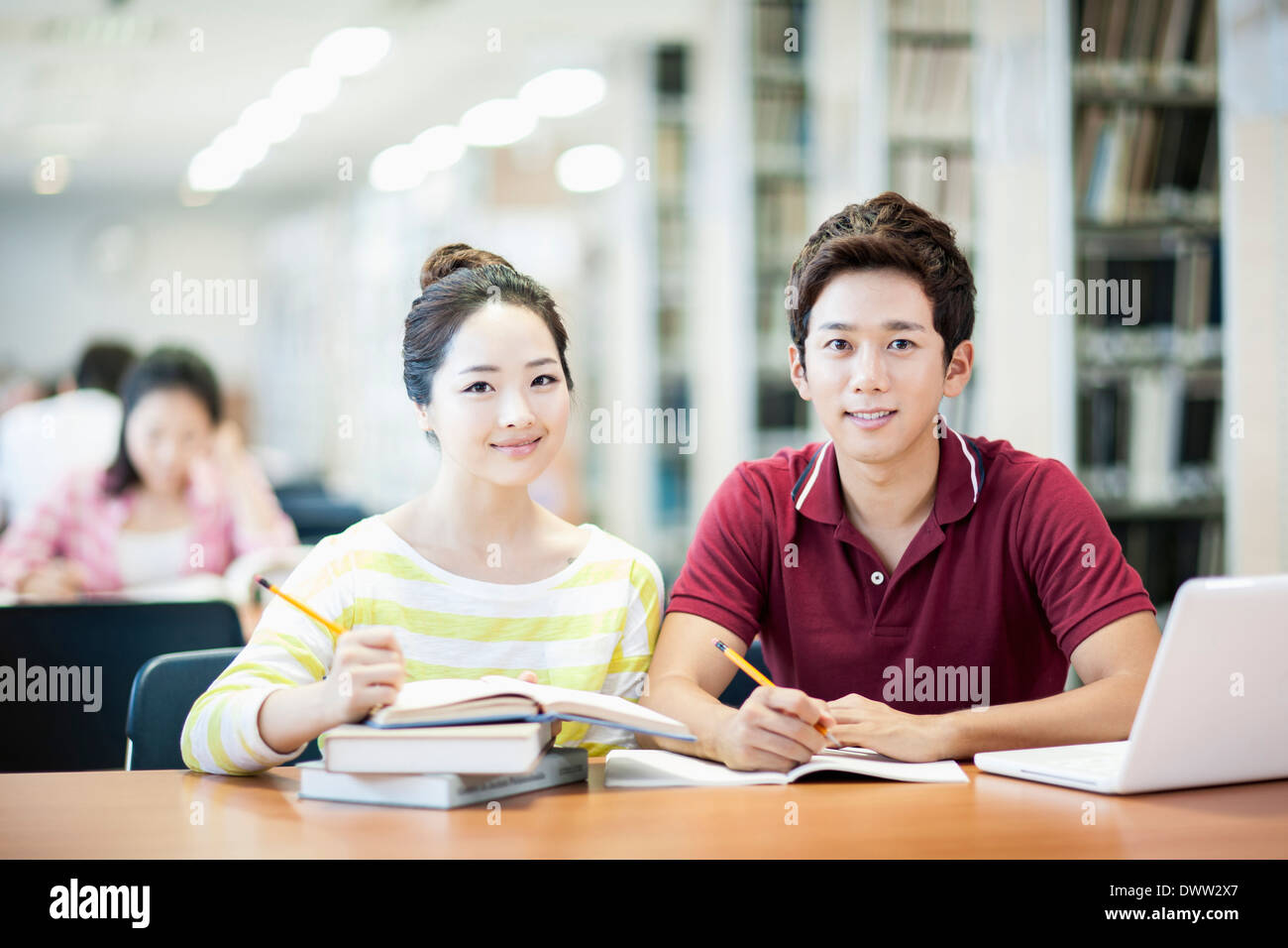 a boy and a girl studying in the library Stock Photo - Alamy