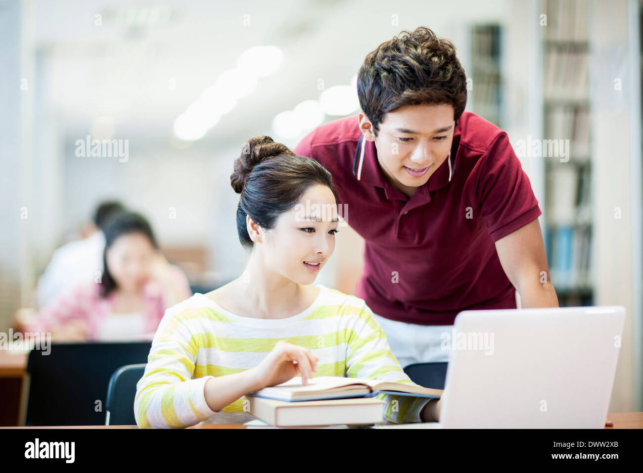 a boy and a girl studying in the library Stock Photo - Alamy