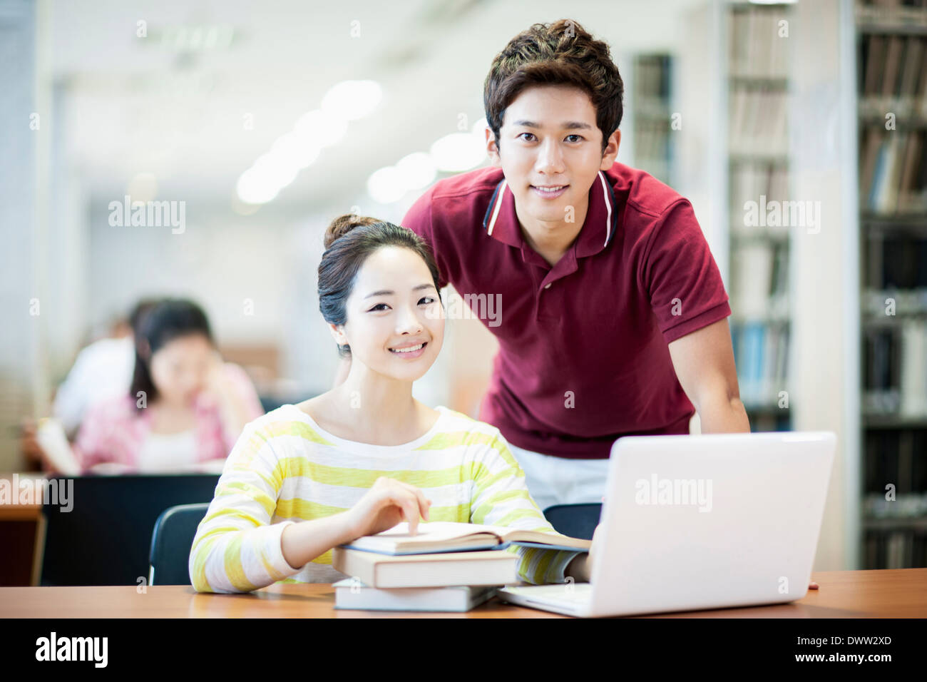 a boy and a girl studying in the library Stock Photo - Alamy