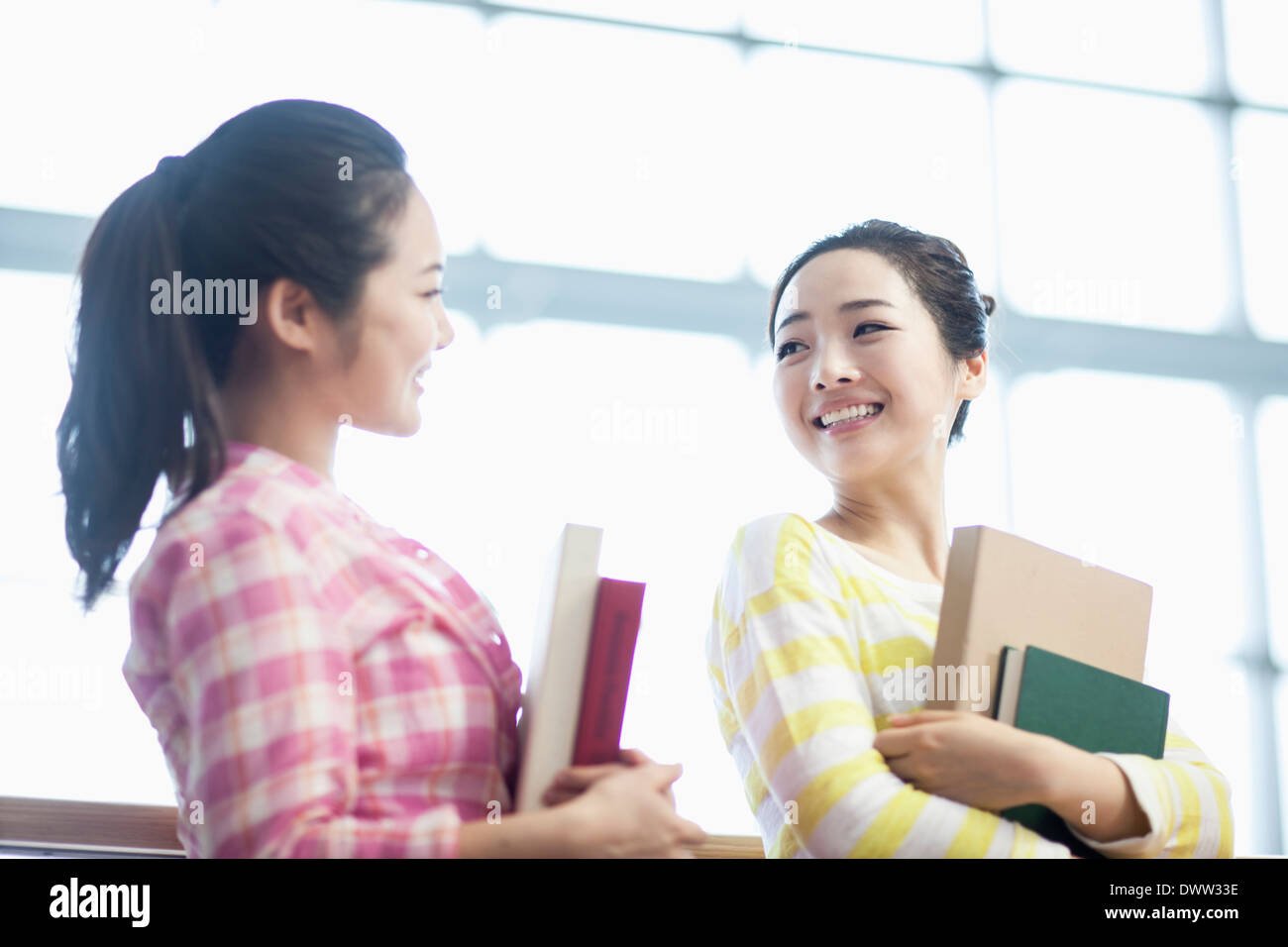 two girls talking in the library Stock Photo - Alamy