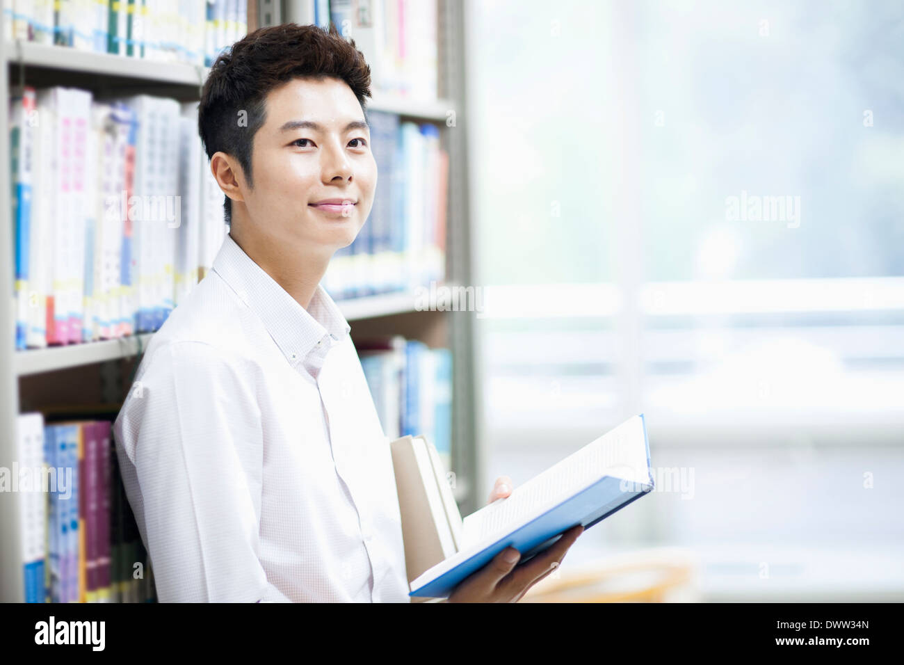 a boy reading a book in the library Stock Photo - Alamy