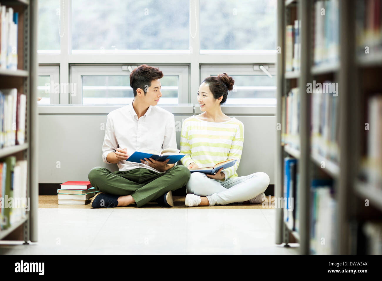 a boy and a girl reading in the library Stock Photo - Alamy