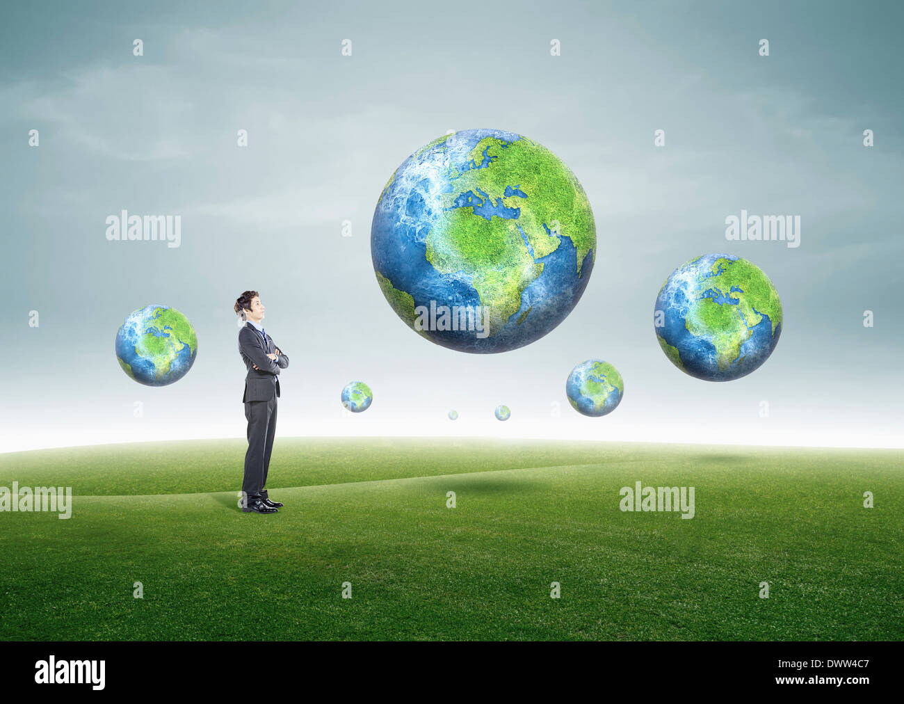 a business man observing the globes Stock Photo - Alamy