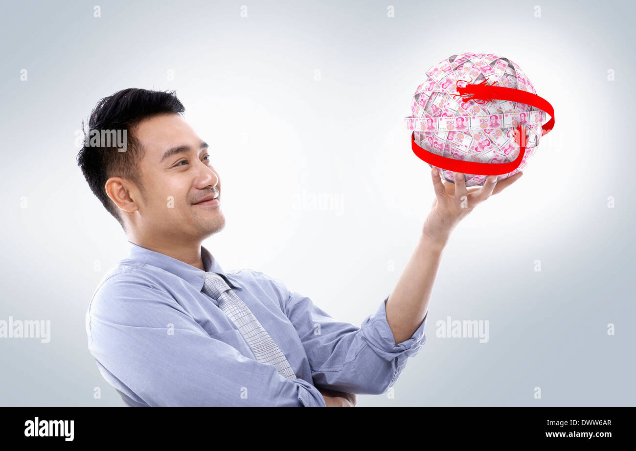 a man holding a ball of money Stock Photo - Alamy