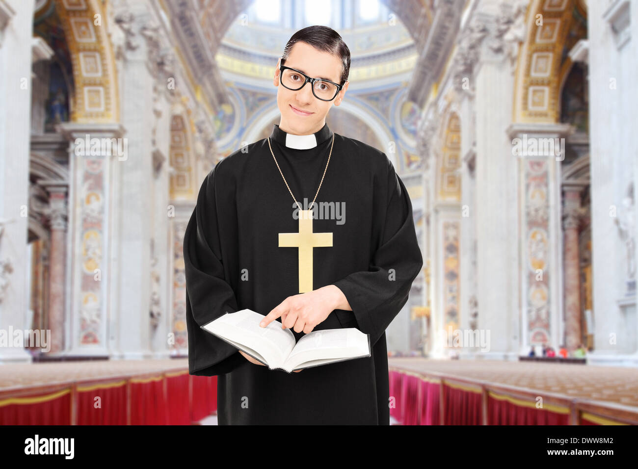 Young male priest pointing on a paragraph of the bible in a cathedral ...