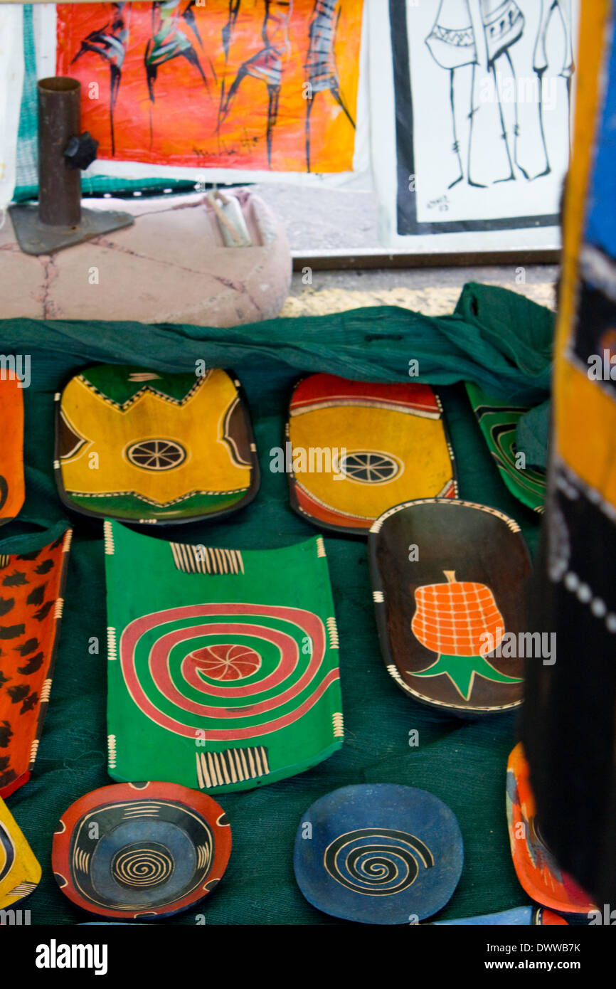 Painted wooden bowls and fabric from Zimbabwe hang at a craft market in ...