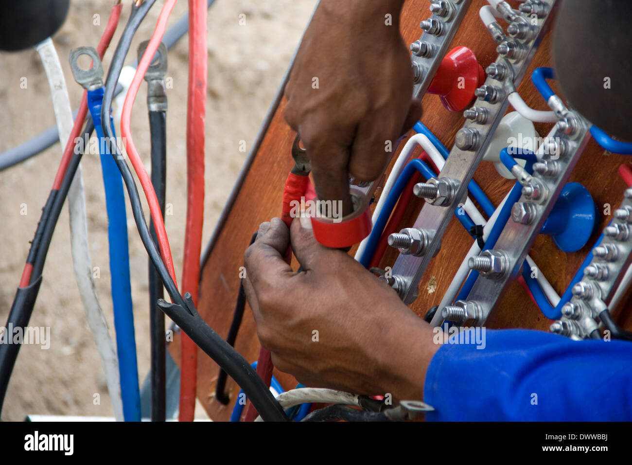 An electrician applying isolation tape around an electric cable on a ...