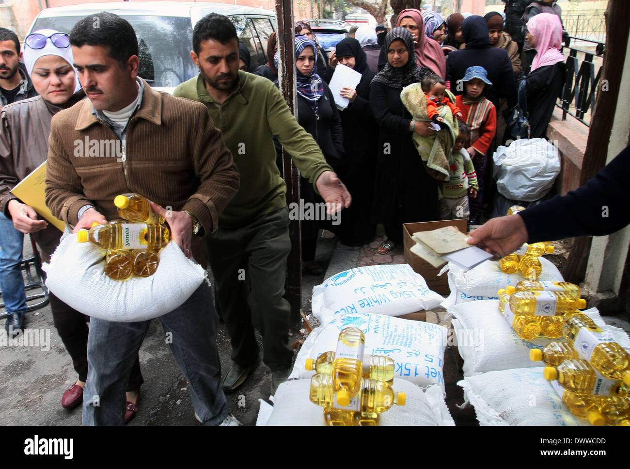 Damascus, Syria. 13th Mar, 2014. Displaced Syrians receive food rations ...