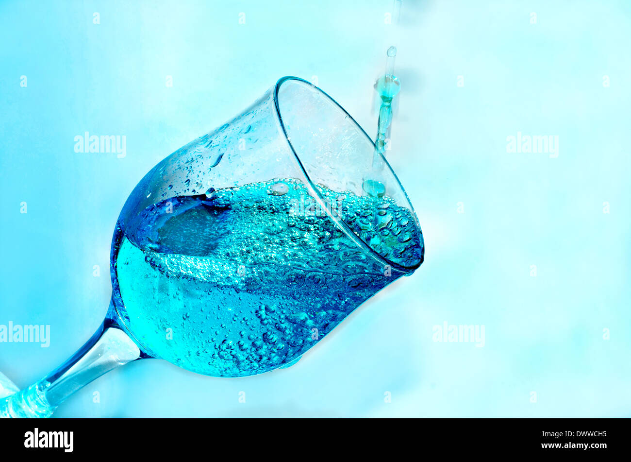 Transparent blue liquid fills the glass glass Stock Photo - Alamy