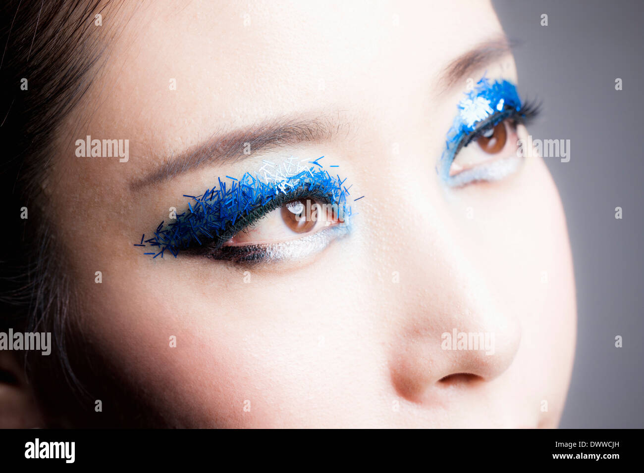 a woman with a black dress and heavy blue make up Stock Photo - Alamy