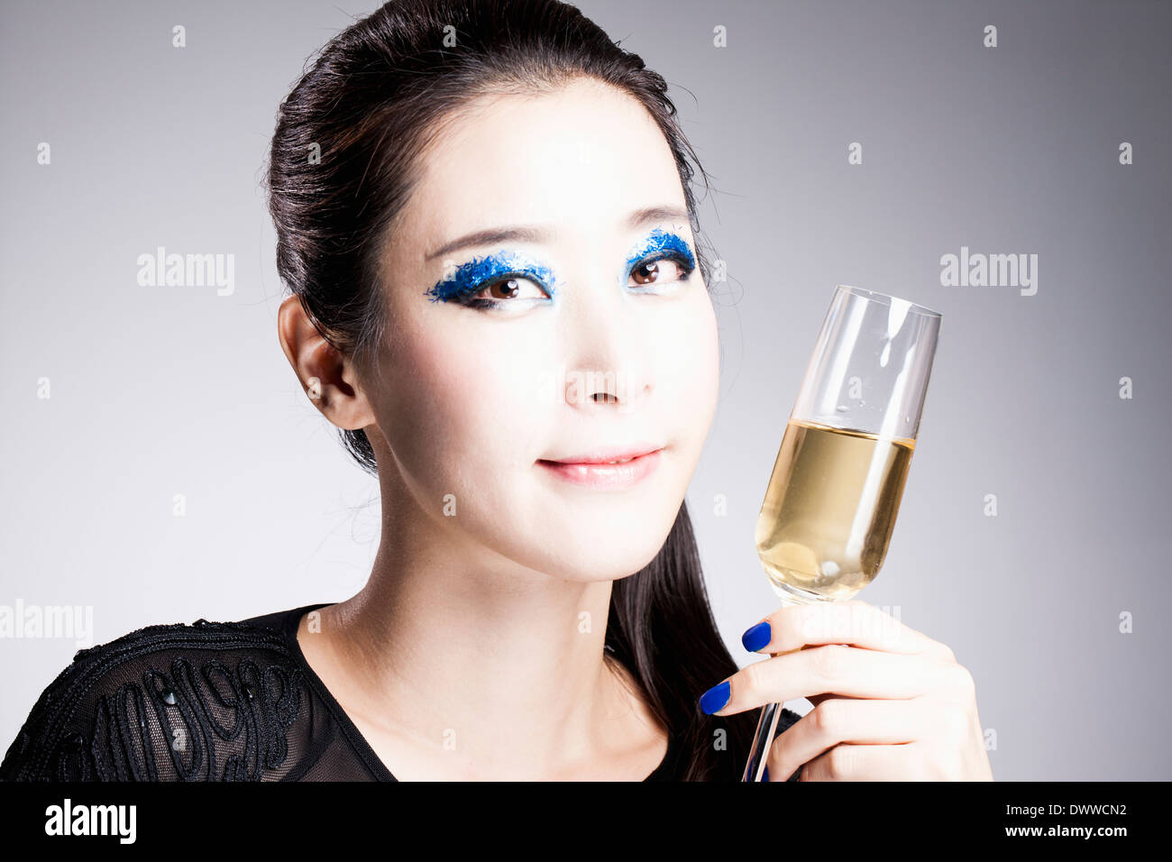 a woman with wine and heavy blue make up Stock Photo - Alamy
