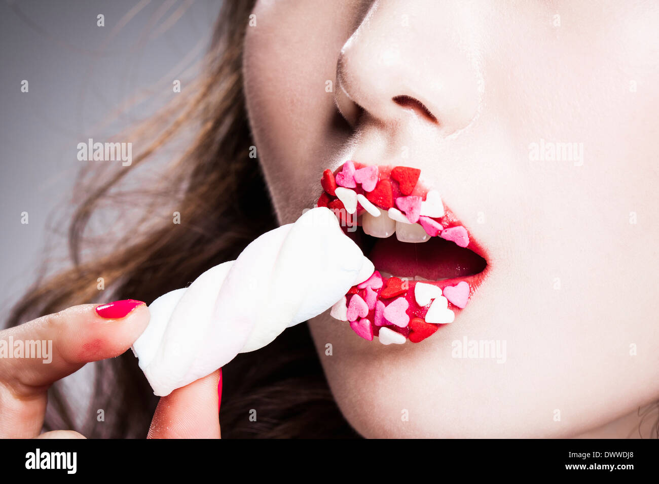 a woman with hearts on her lips eating candy Stock Photo - Alamy