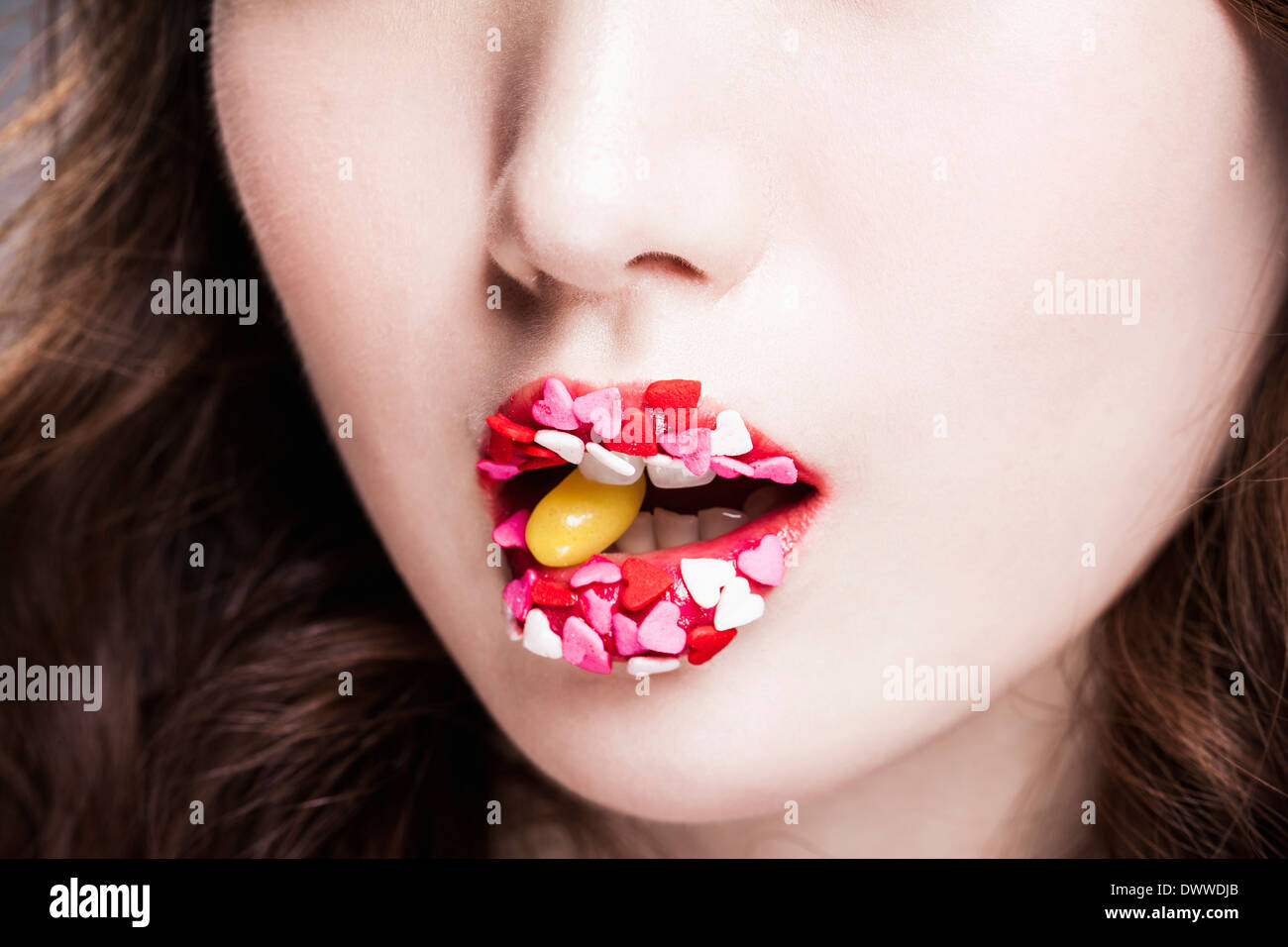 a woman with hearts on her lips eating candy Stock Photo - Alamy