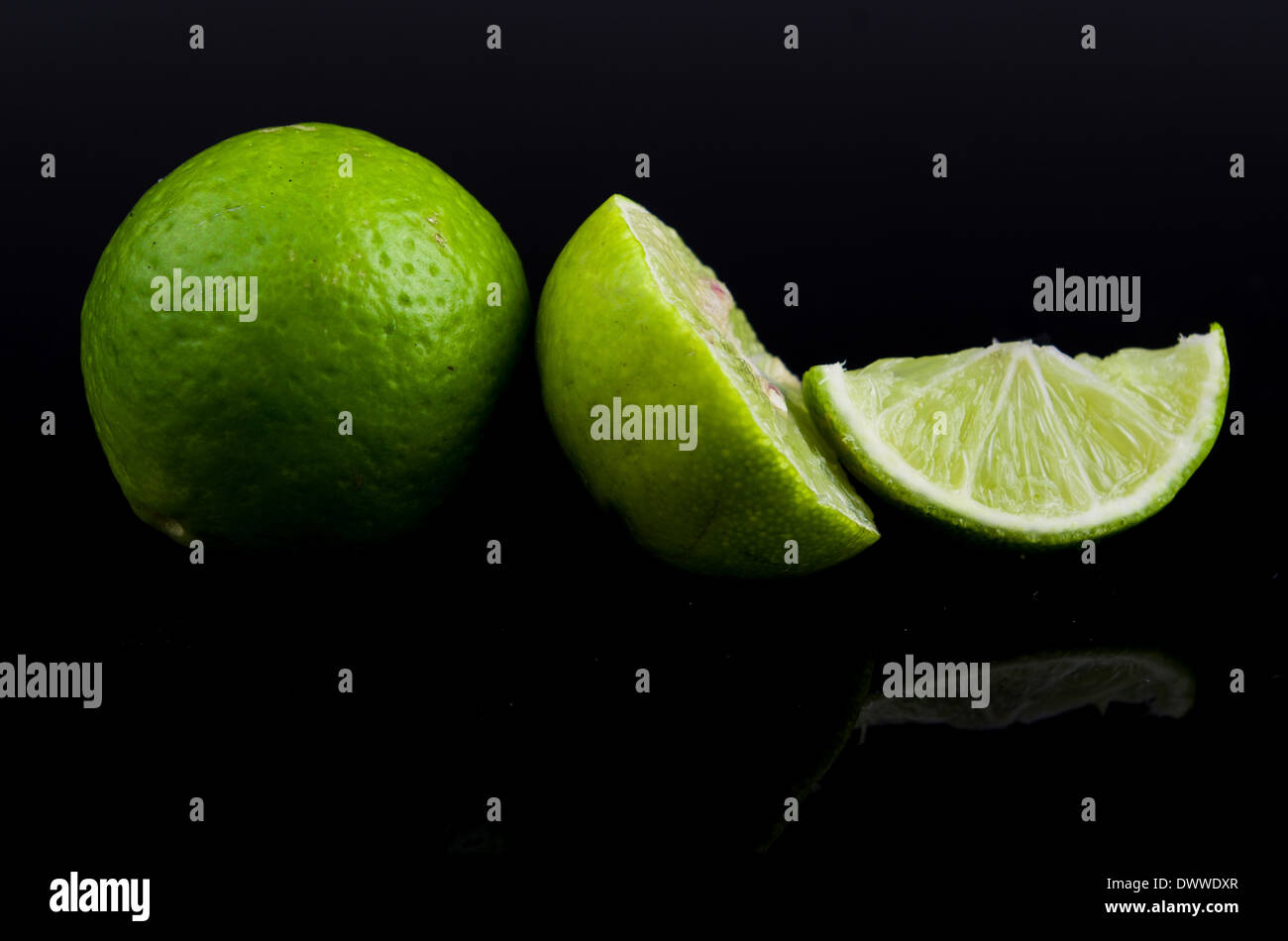 Citrus lime fruit half on black background, small green lemons Stock ...
