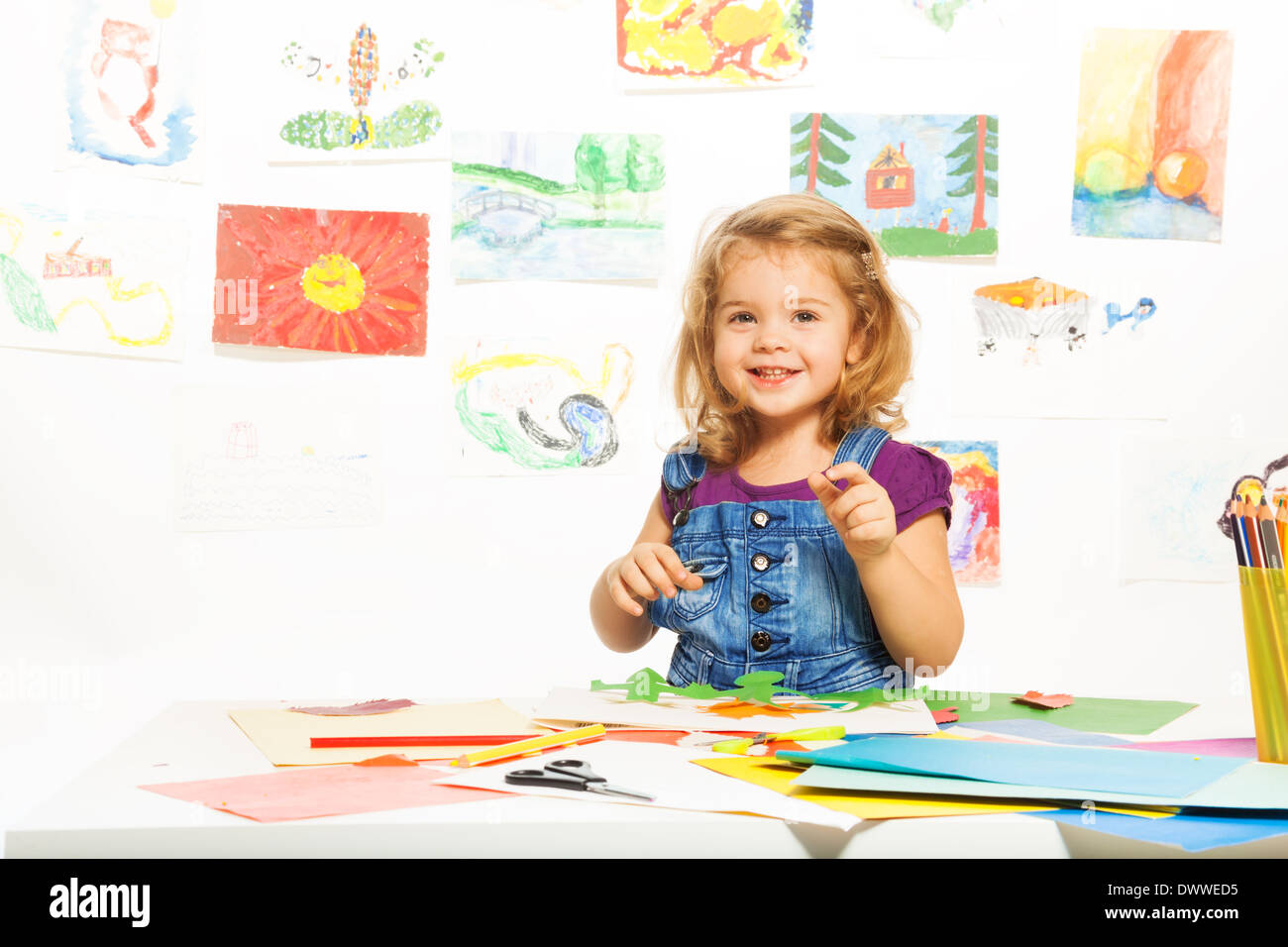 Little 3 years old blond girl gluing color cardboard smiling and ...