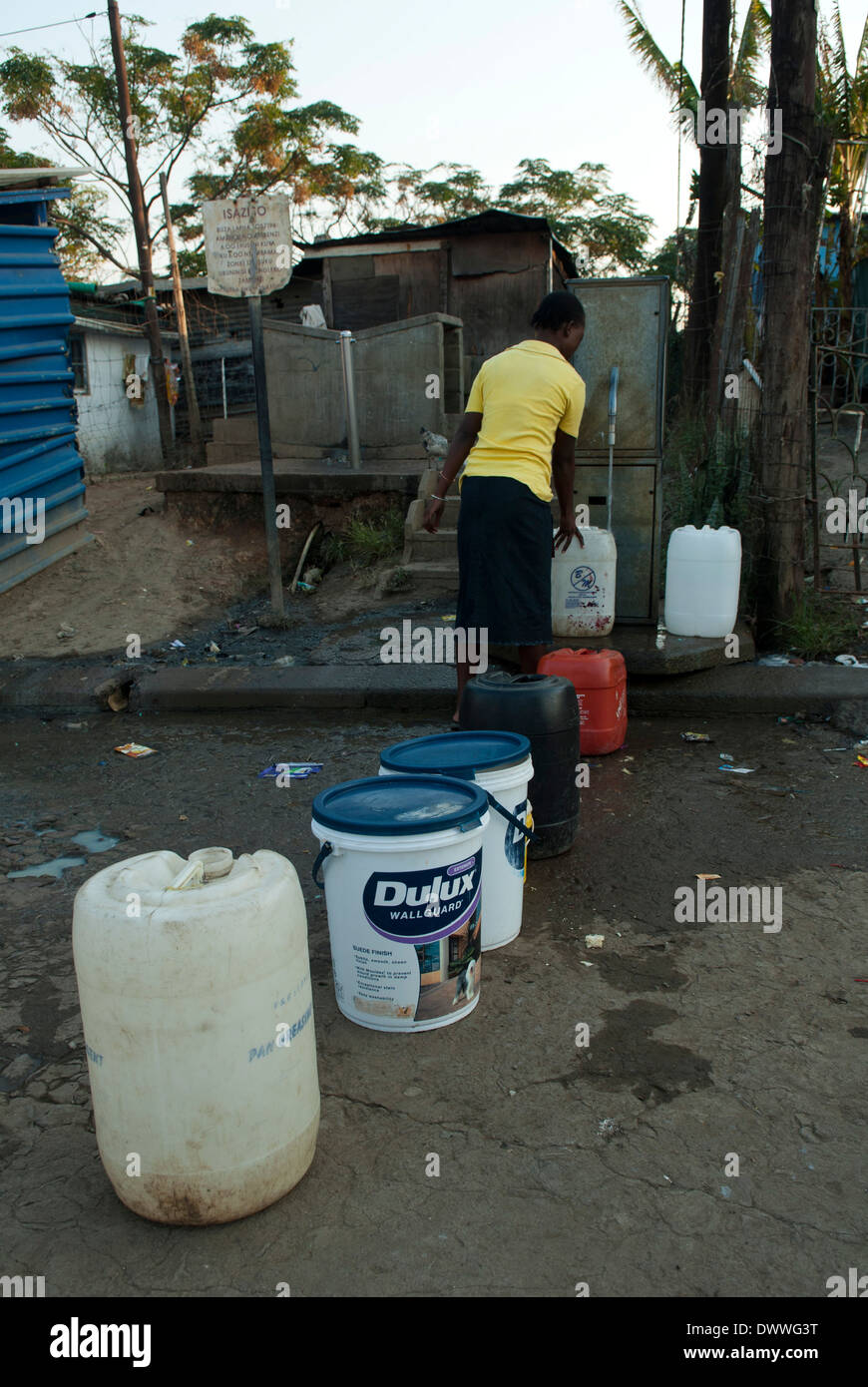 A woman collects water from a communal tap at the Kennedy Road informal ...