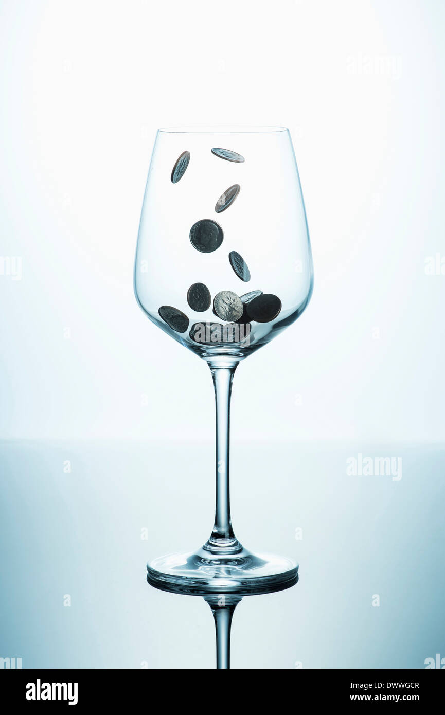 a wine glass with coins Stock Photo - Alamy