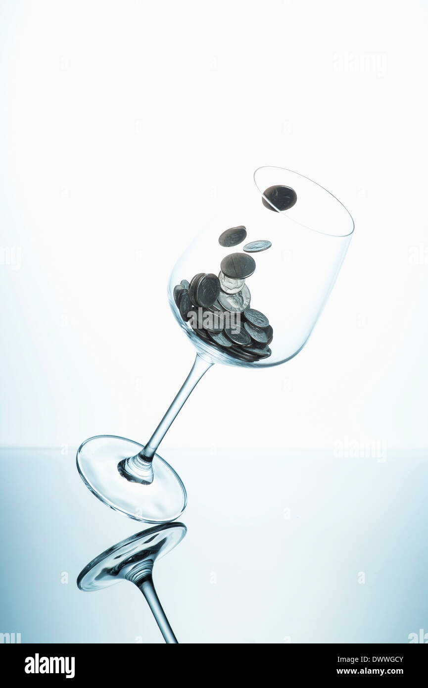 a wine glass with coins Stock Photo - Alamy