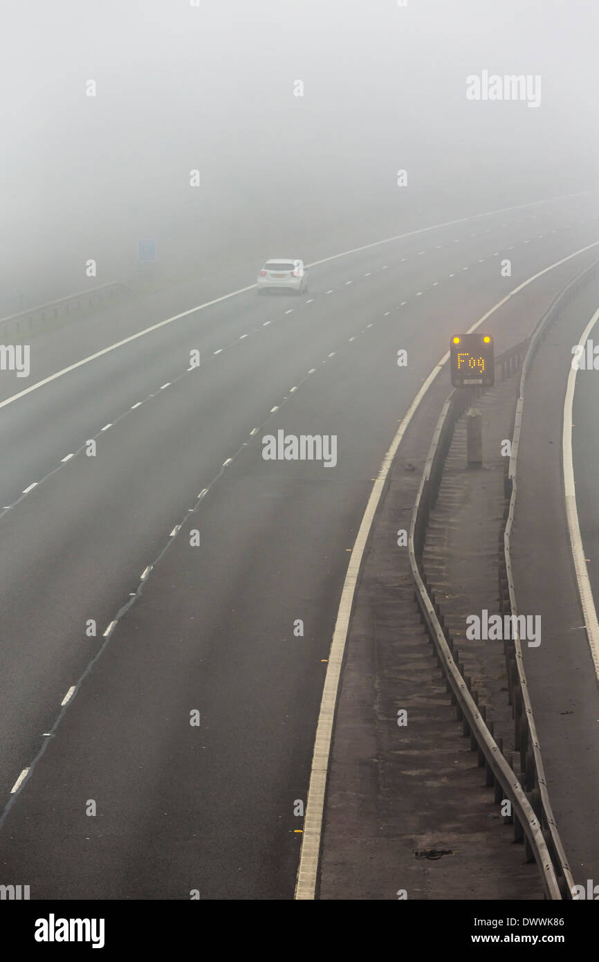 UK motorway with fog warning sign in fog or foggy conditions Stock ...