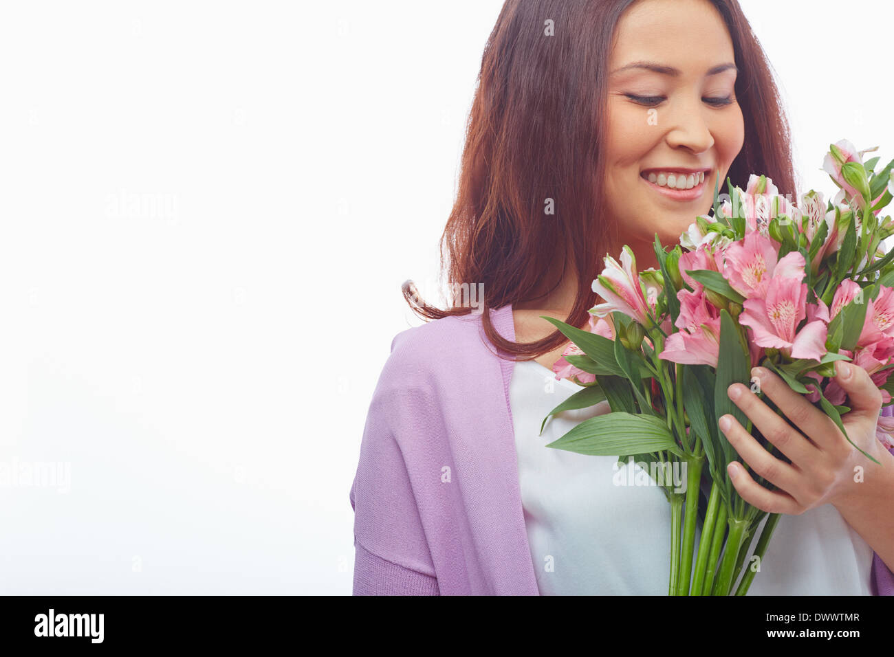Portrait of charming female looking at bunch of fresh flowers Stock ...