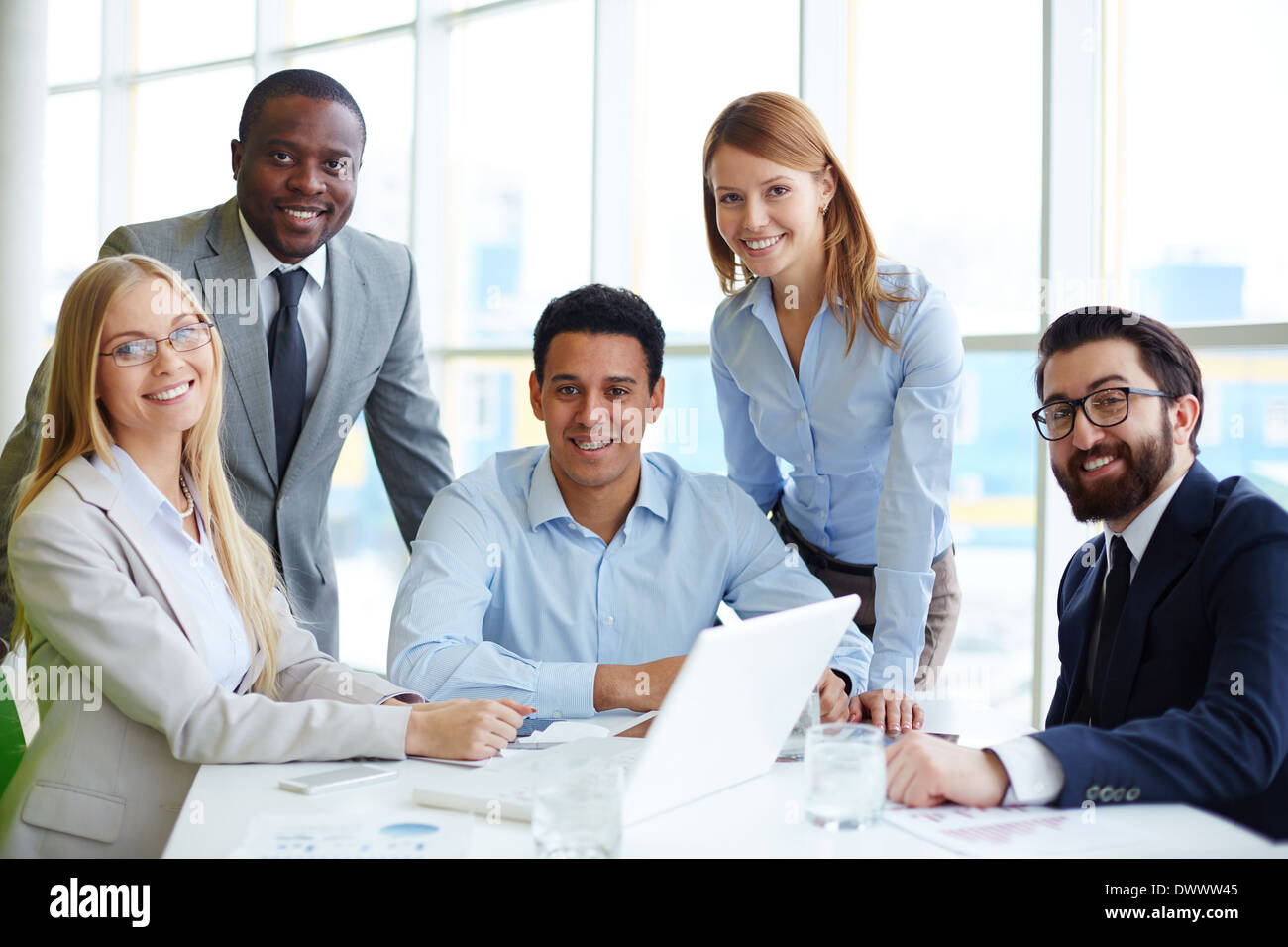 Company of five employees sitting at workplace in office Stock Photo ...