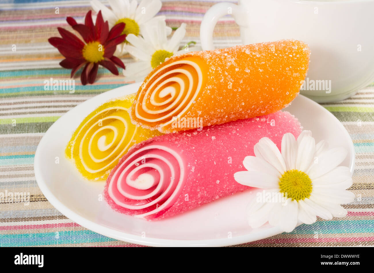 colorful fruit candy on a plate with chamomile and chrysanthemum flower ...