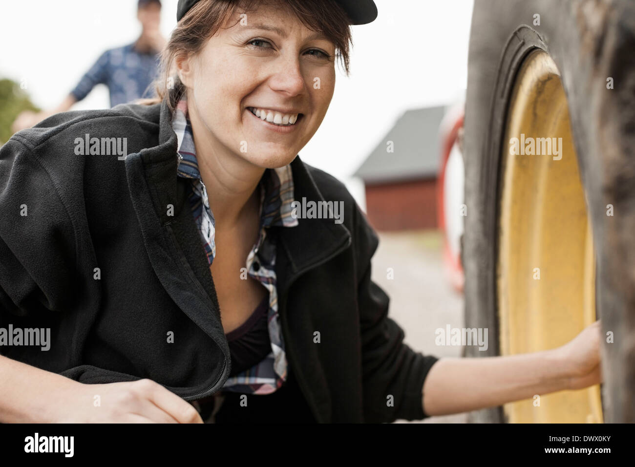 Portrait of smiling female farmer repairing tractor wheel Stock Photo ... Portrait of smiling female farmer repairing tractor wheel Stock Photo ...