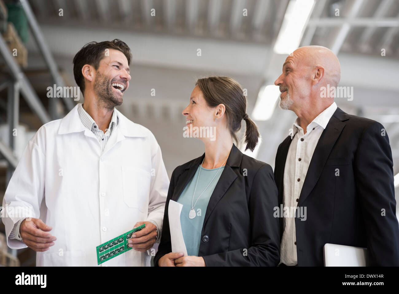 Happy male engineer and business people in manufacturing plant Stock ...