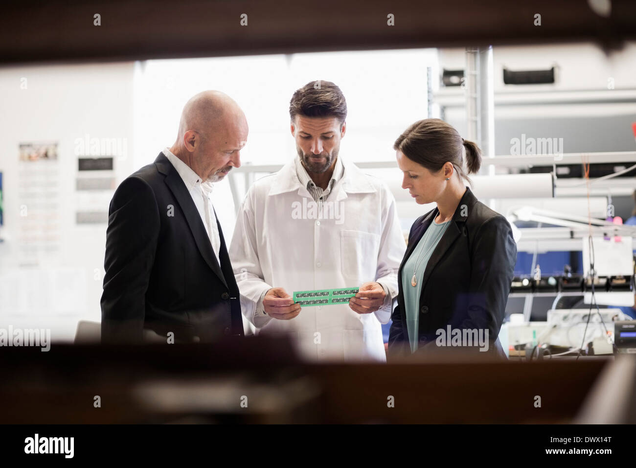 Engineer discussing machine with business people in factory Stock Photo ...