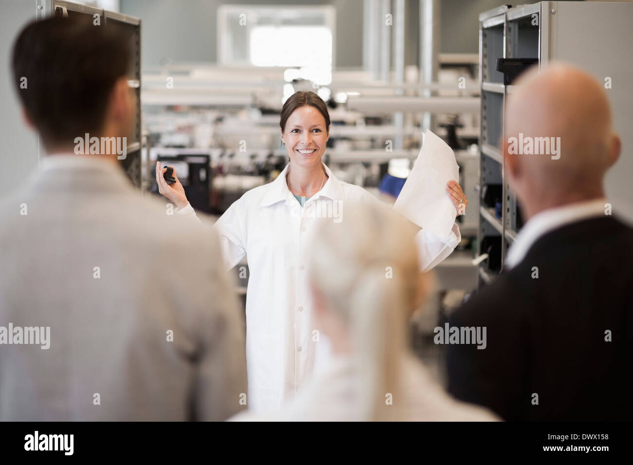 Female engineer explaining business people in manufacturing industry ...