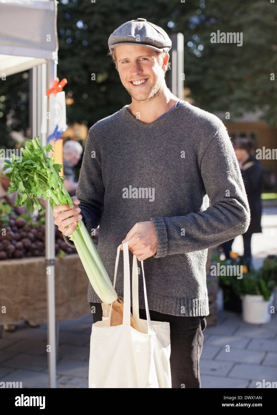 Portrait of happy man holding celery in market Stock Photo - Alamy