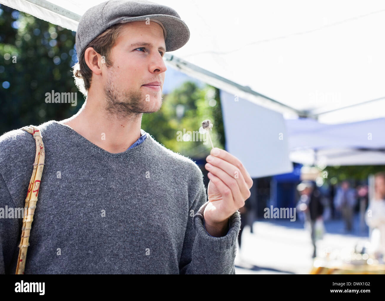 Thoughtful man eating with toothpick at market Stock Photo - Alamy