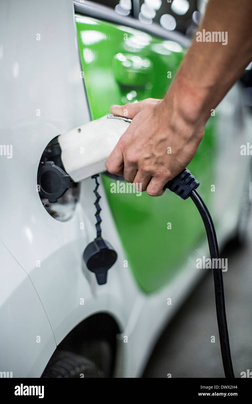 Cropped image of man charging electric car at gas station Stock Photo ...