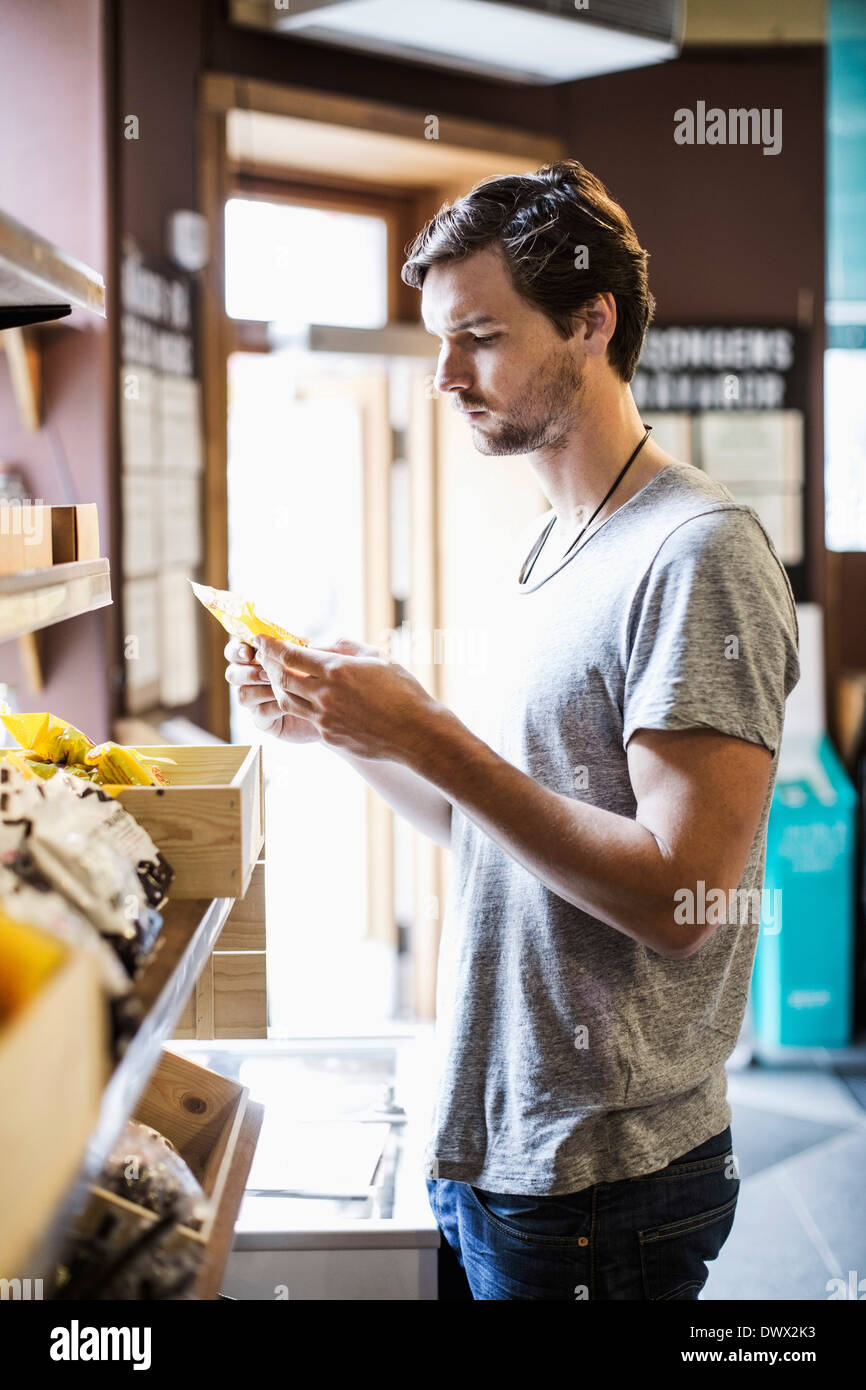 Young man reading label in grocery store Stock Photo - Alamy