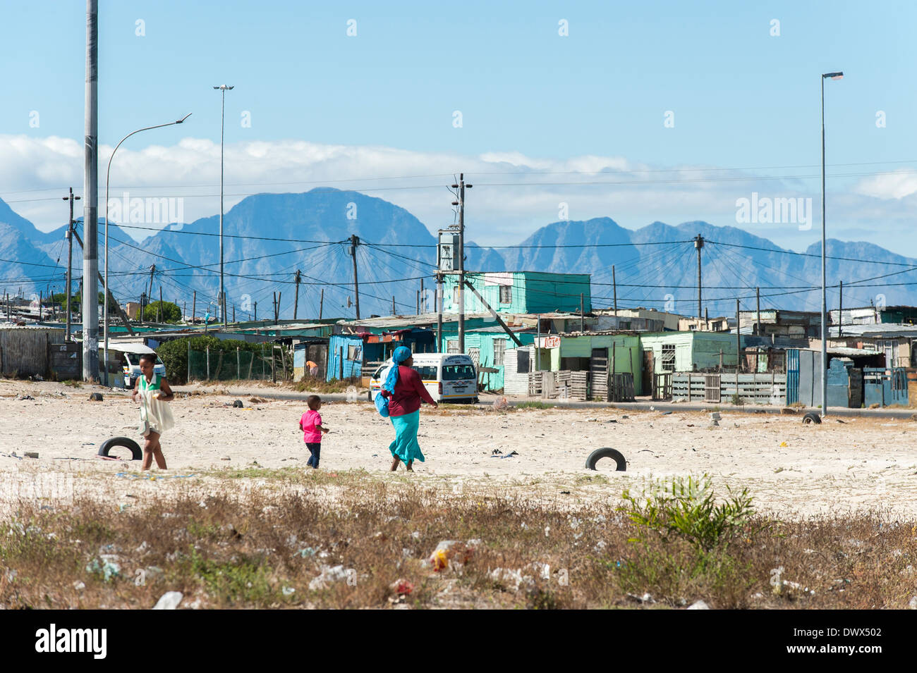Woman with child crossing a sandy playground in Khayelitsha, Cape Town ...