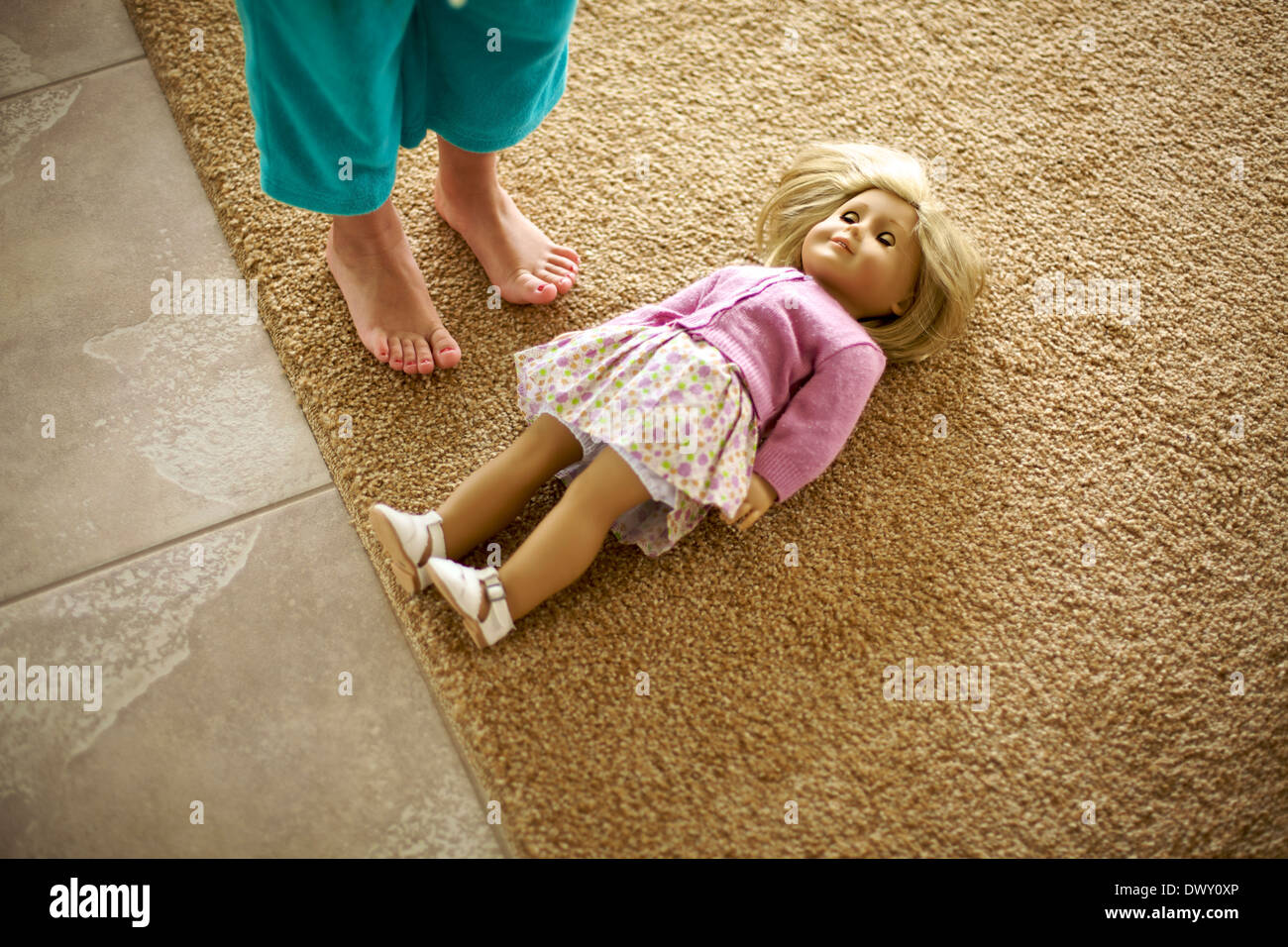 Girl with doll lying on ground Stock Photo - Alamy