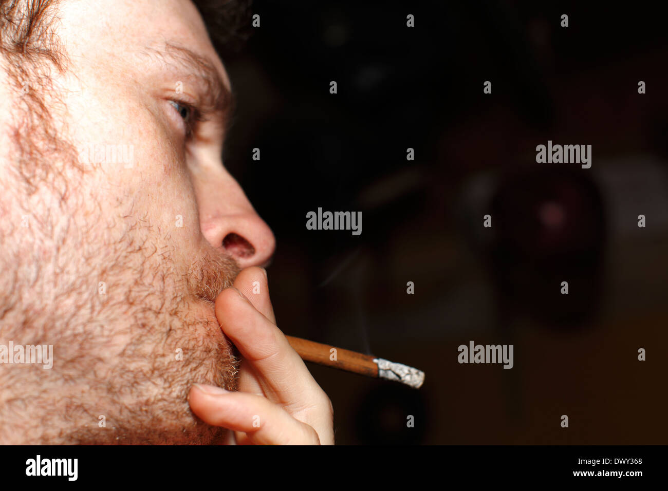 Man smoking small clove cigarette Stock Photo - Alamy